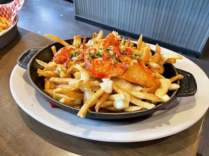 Golden fries meet sweet lobster chunks in this cast-iron skillet of pure indulgence, proving that some of life's best moments involve melted cheese.