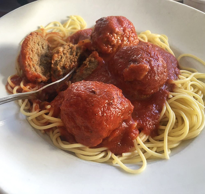 These aren't just any meatballs &ndash; they're edible poetry atop a perfect tangle of spaghetti, swimming in sauce that whispers family secrets.