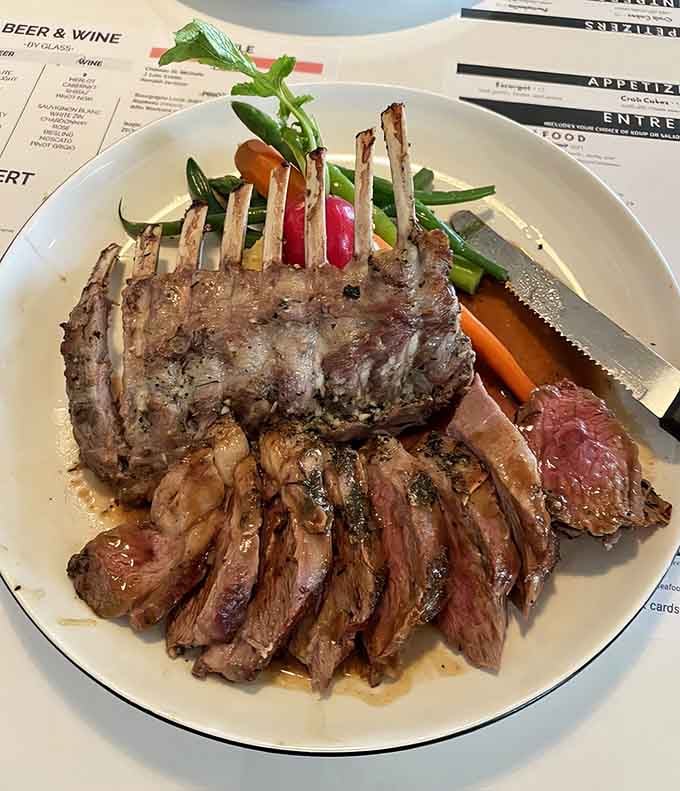 Perfectly cooked lamb stands proud on the plate, accompanied by sliced steak because one spectacular protein apparently isn't enough.