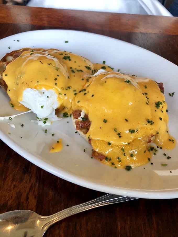 Behold the Eggs Benedict in all its glory, with hollandaise cascading over perfectly poached eggs like liquid sunshine.