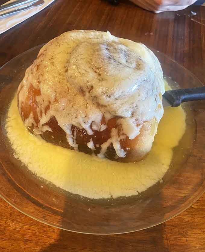 Behold the cinnamon roll that launched a thousand road trips, drowning in icing and defying all reasonable portion expectations.