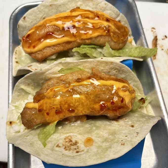 Golden walleye tacos drizzled with sauce and nestled in soft tortillas represent Minnesota lake country at its most delicious.