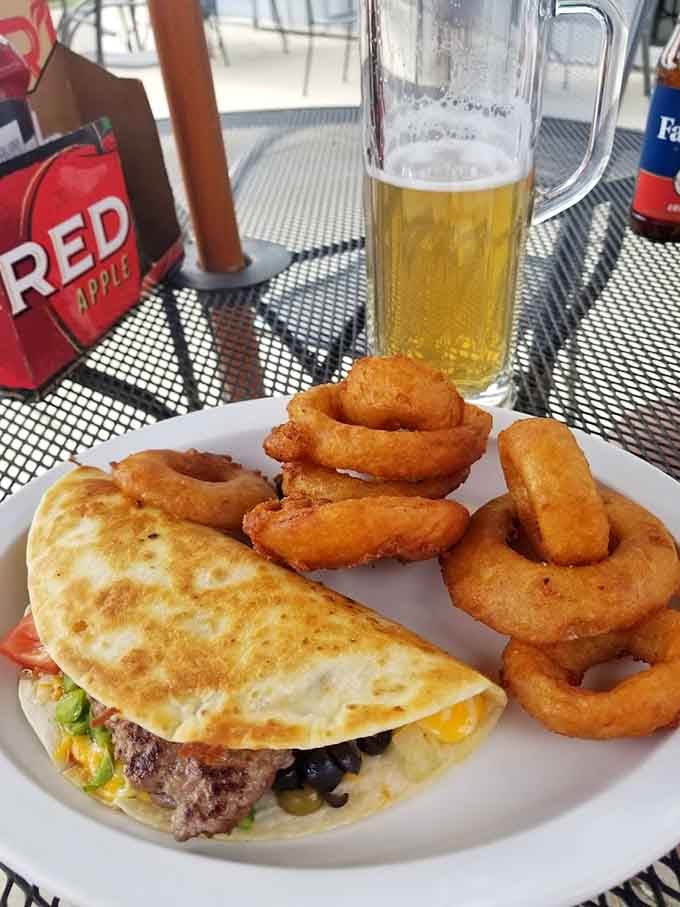 This loaded quesadilla paired with golden onion rings proves Topper's menu extends far beyond their famous wings.