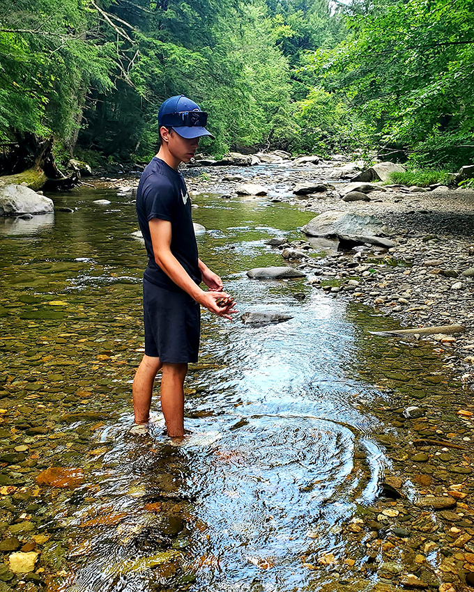 A moment of zen as a visitor connects with the river. No phones, no notifications, just the timeless conversation between human and flowing water.