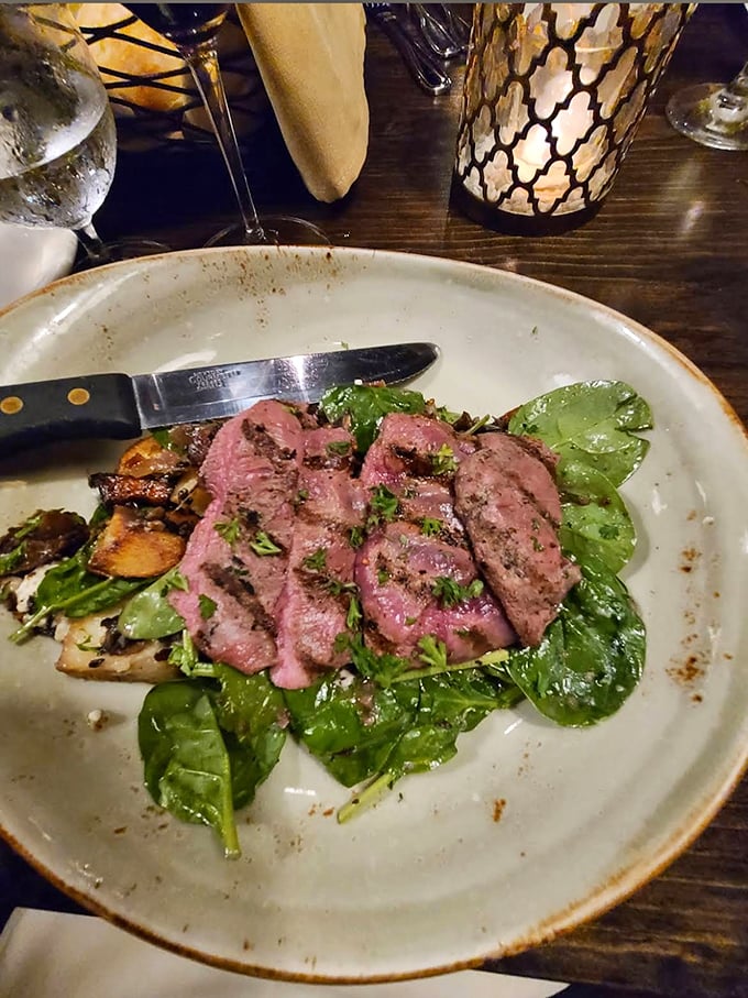 Perfectly pink venison medallions lounging on fresh greens &ndash; it's like the deer volunteered for this delicious mission.