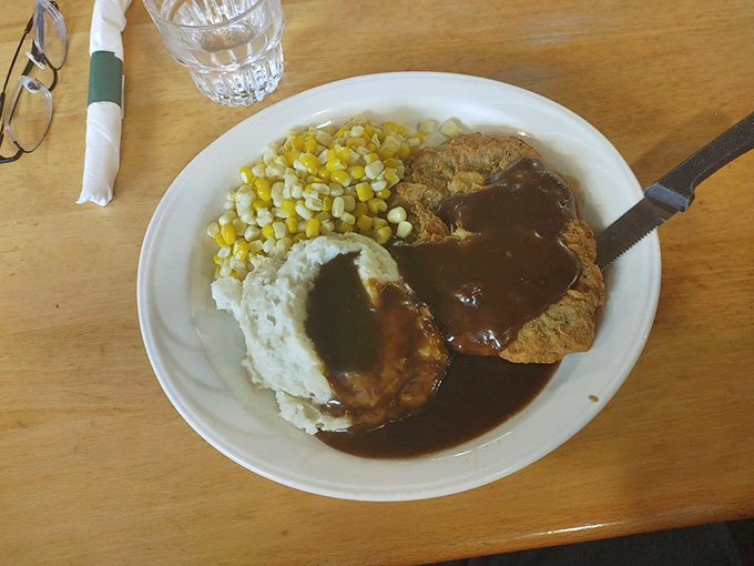 Chicken fried steak swimming in gravy with sides that understand the assignment: comfort food perfection achieved.