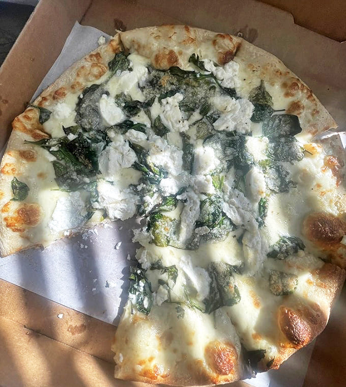 The White Pizza combines ricotta, mozzarella, and fresh spinach in perfect harmony – a creamy dream that proves tomato sauce isn't always necessary.