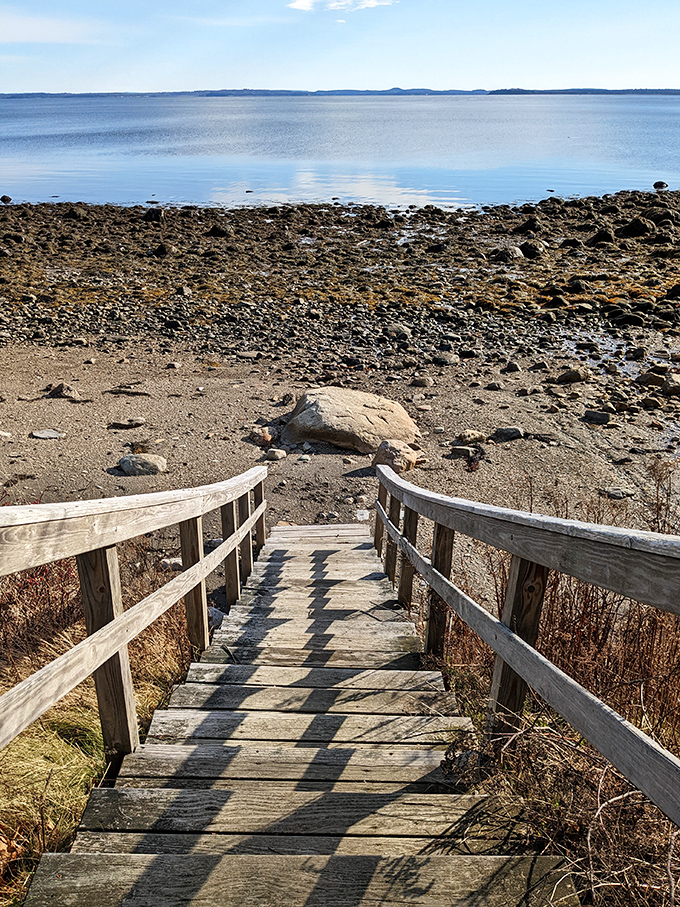 Wooden stairs invite exploration down to the shoreline, where each tide reveals new treasures among the rocks and pools below.