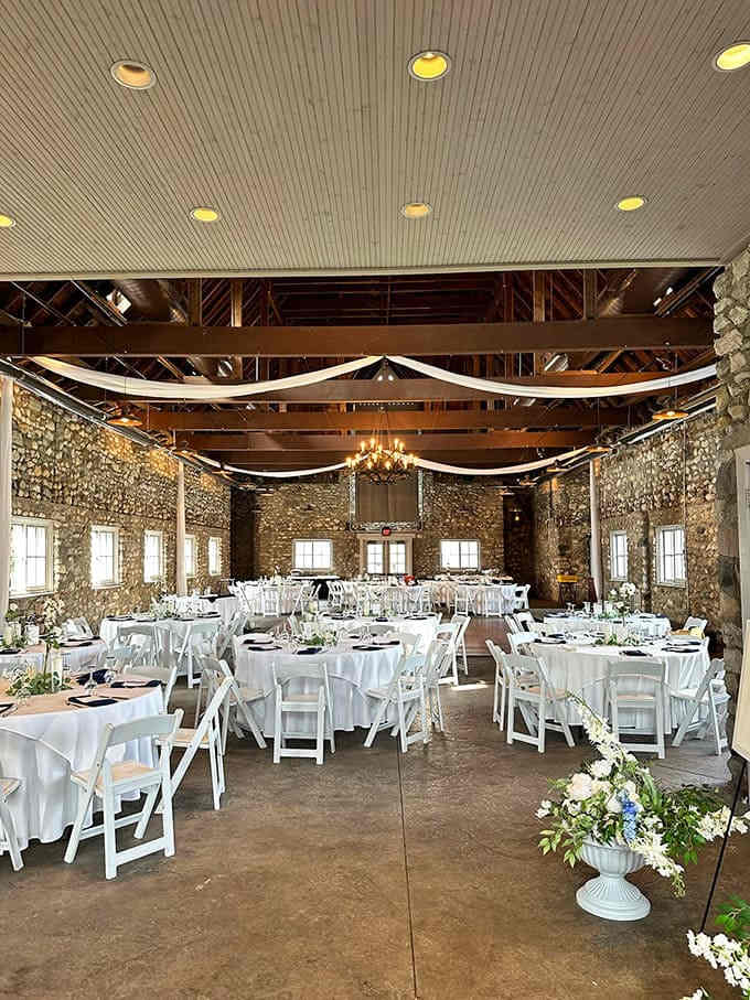 Elegant simplicity reigns in the dining area, where stone walls and white linens create the perfect backdrop for celebrations both grand and intimate.