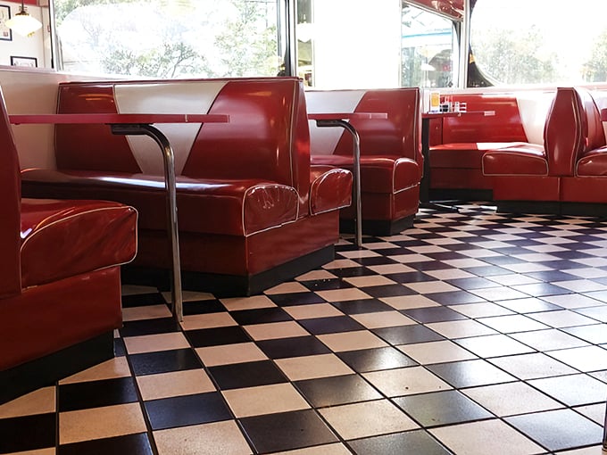 Step into a Technicolor dream! Red vinyl booths and checkerboard floors set the stage for culinary nostalgia.