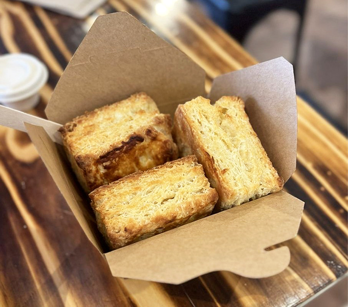 The biscuit box offers portable happiness &ndash; three golden-brown beauties nestled together in kraft paper, ready to transform any ordinary day into something special.