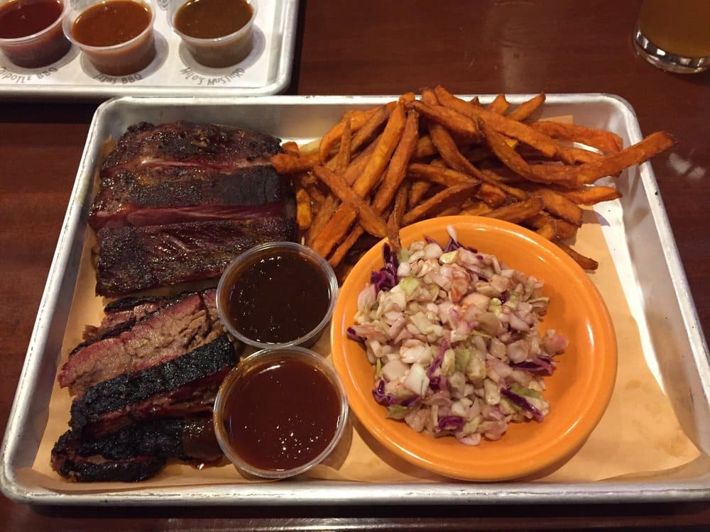 A barbecue lover's paradise on a tray, where tender meats meet their perfect match in crispy sweet potato fries and tangy slaw.