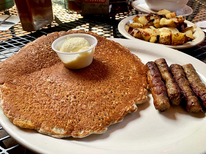 Breakfast of champions: a hearty stack of buckwheat pancakes alongside perfectly browned sausage links and home-style potatoes.