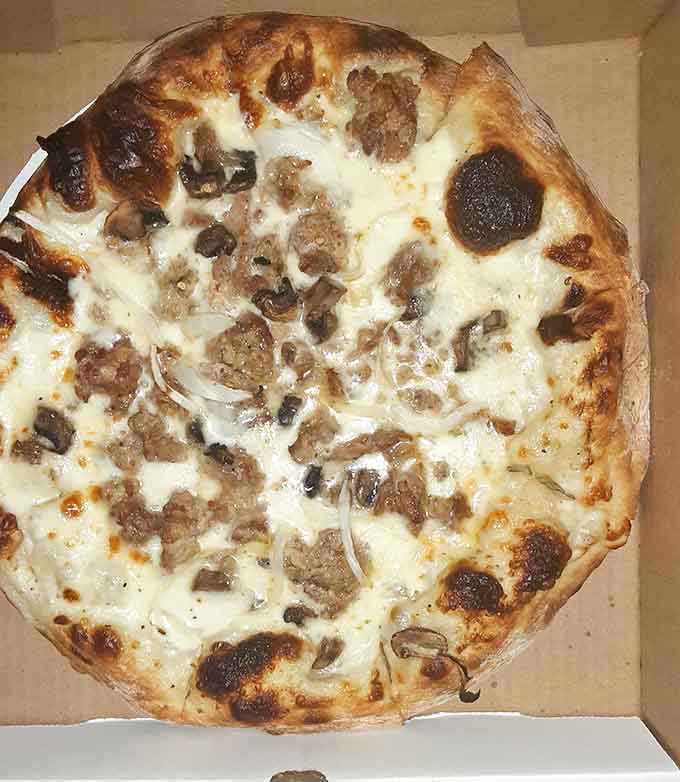 That perfectly charred crust and generous toppings create the kind of pizza that makes you understand why people take food photos.