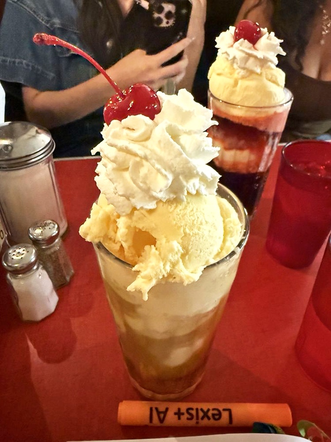 The butterscotch soda float arrives like a tower of golden deliciousness, topped with a cloud of whipped cream and that essential cherry.
