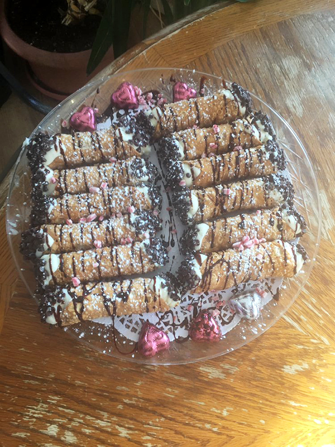 Sweet endings come in the form of these cannoli &ndash; delicate pastry shells filled with creamy goodness and decorated with chocolate drizzle and powdered sugar.