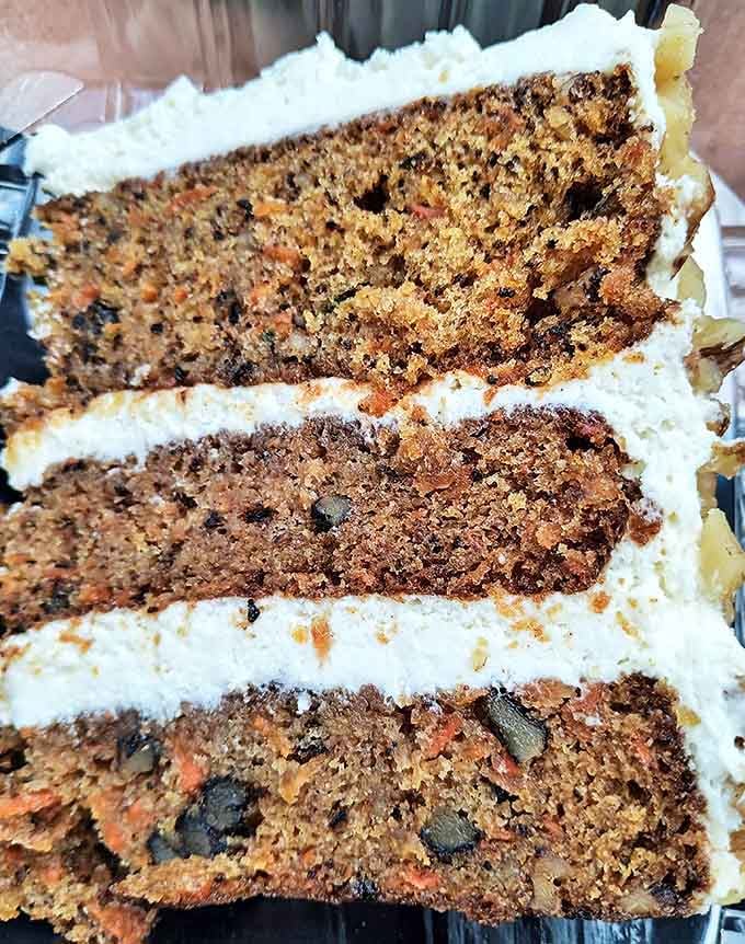 Close-up of the legendary carrot cake shows the perfect crumb texture, studded with carrot flecks and spices &ndash; architecture you can eat.