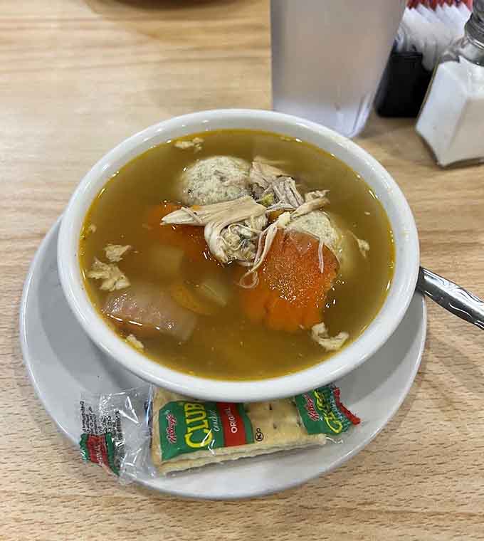 Golden chicken soup with tender matzo balls floats like edible clouds, offering comfort that would make any grandmother proud of this bowl.