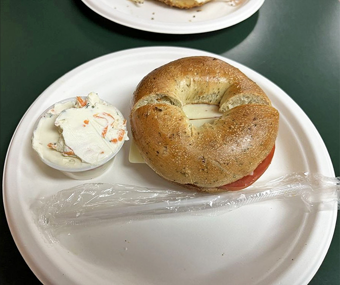 Cheese and tomato sandwich with cream cheese: Simplicity perfected – a fresh bagel adorned with creamy cheese and bright tomato slices. Sometimes less truly is more.
