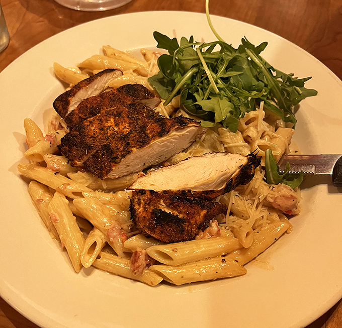 The penne carbonara delivers creamy indulgence with perfectly blackened chicken providing a spicy counterpoint to the smooth sauce.