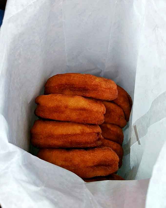 Golden-brown cider donuts nestled in paper &ndash; simple perfection that's worth every mile of the drive to Ashtabula County.