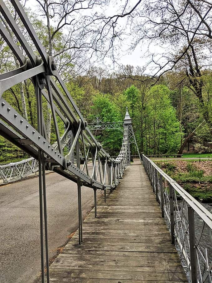 Walking the wooden planks of the pedestrian pathway offers a unique perspective, with intricate ironwork framing views of the flowing creek below.
