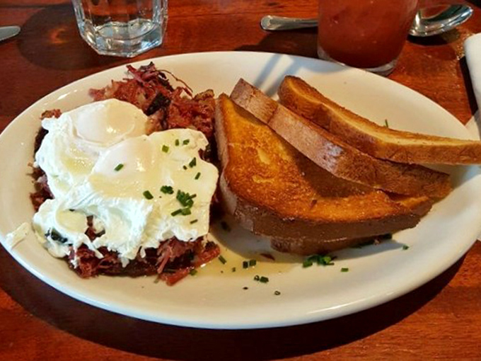 Each forkful combines crispy-edged corned beef, golden potatoes, and runny egg yolk in a breakfast symphony worth crossing state lines for.