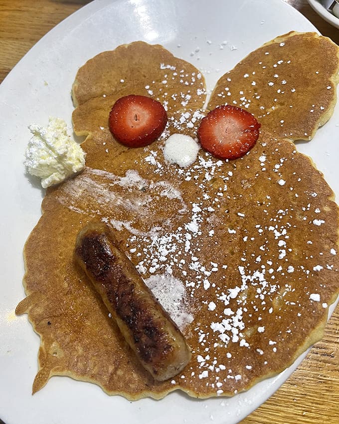 These pancakes wear their toppings like jewelry, each strawberry and dusting of sugar placed with the care of a master craftsman.