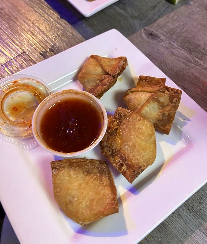 Golden-brown crab rangoons shatter delightfully when bitten, revealing a filling that actually tastes like crab &ndash; a bar food miracle!