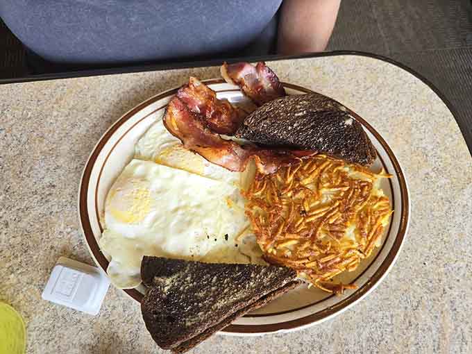 Hash browns achieving that elusive golden perfection alongside eggs and toast, the holy trinity of breakfast done exactly right every single time.