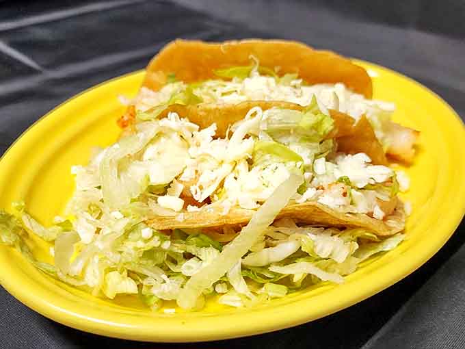 Crispy taco shells overflow with seasoned meat and fresh toppings, proving simplicity done right beats complexity done wrong.
