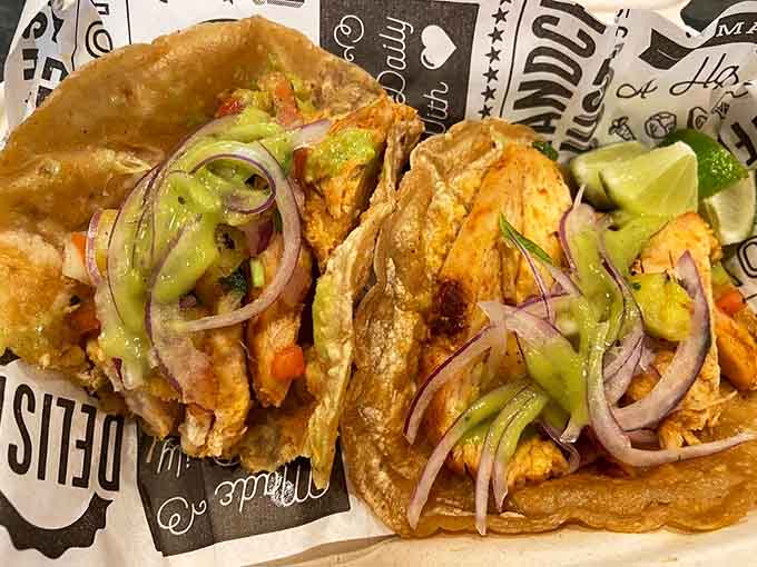 The chicken tacos glisten with perfectly grilled meat, topped with fresh onions and cilantro that add crunch and brightness to every bite.