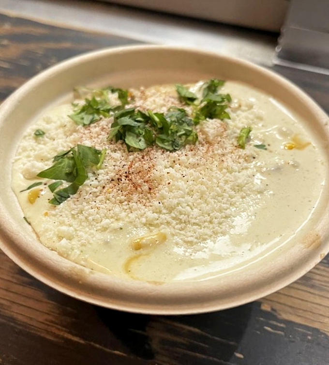Elote in a cup - roasted corn elevated with tomatillo crema, cilantro, cotija cheese and a dusting of chile powder.