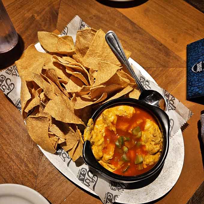 Buffalo Chicken Dip bubbles in its skillet, creamy and spicy, ready to disappear faster than you can say "pass the chips."