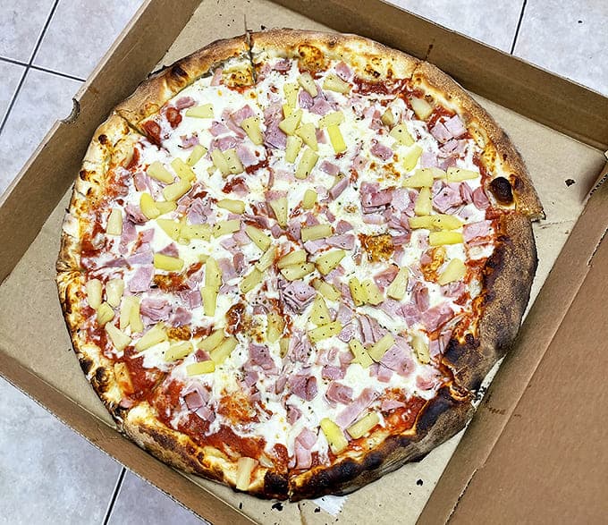 Hawaiian Pizza done right – thin-sliced ham and sweet pineapple on a perfectly charred crust that balances sweet and savory in every bite.
