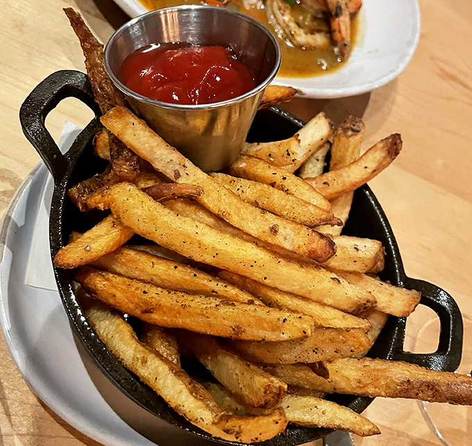 Golden fries served in cast iron &ndash; crispy outside, fluffy inside, and seasoned with herbs that'll have you licking your fingers shamelessly.