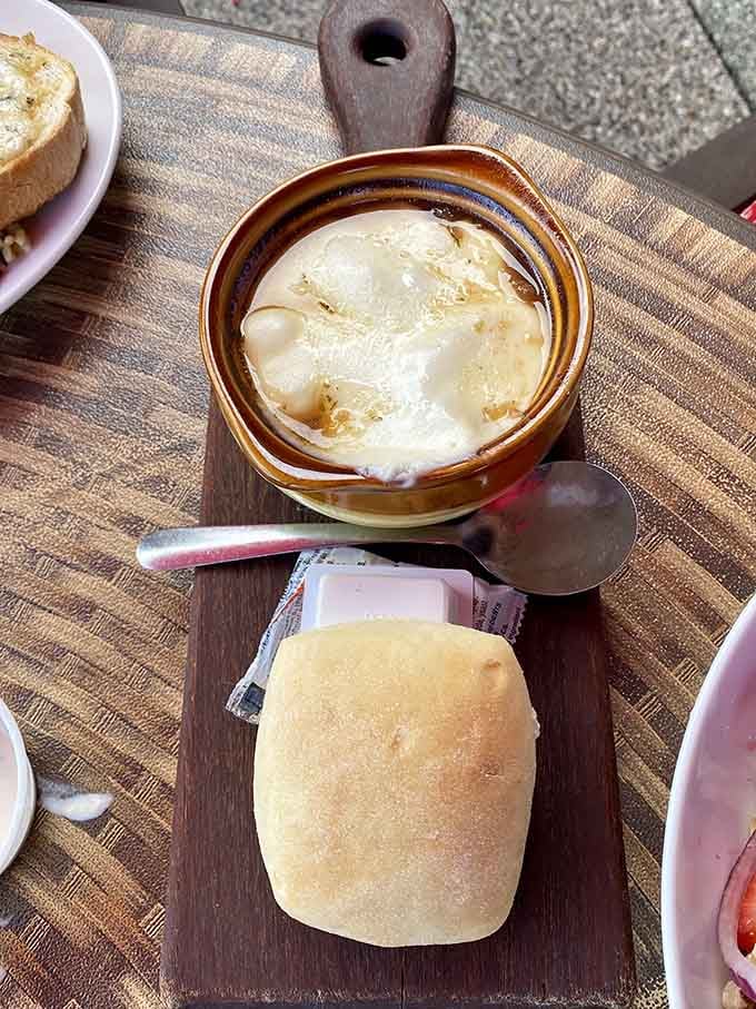 That perfectly toasted bread sitting in rich broth under a cheese blanket is basically a hug in crock form.