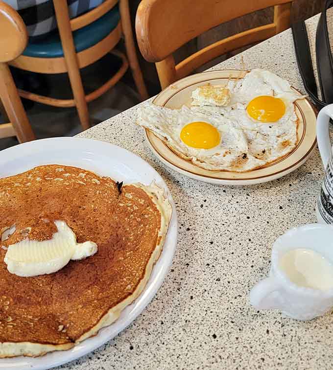 This is what breakfast is supposed to look like: fluffy pancakes meeting perfectly cooked eggs in a combination that's been working since diners were invented.