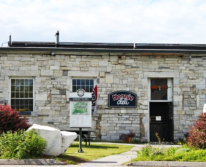 The stone building stands proud, with landscaping that says "We care about more than just sandwiches here."