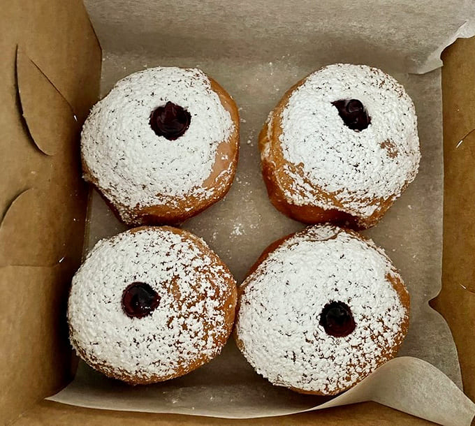 Powdered sugar-dusted beauties that look like they belong at a fancy celebration, not a donut shop.