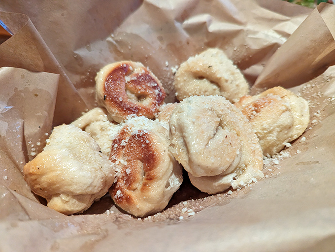 These aren't just garlic knots – they're pillowy clouds of dough transformed into buttery, garlicky perfection that'll have you reaching for "just one more."