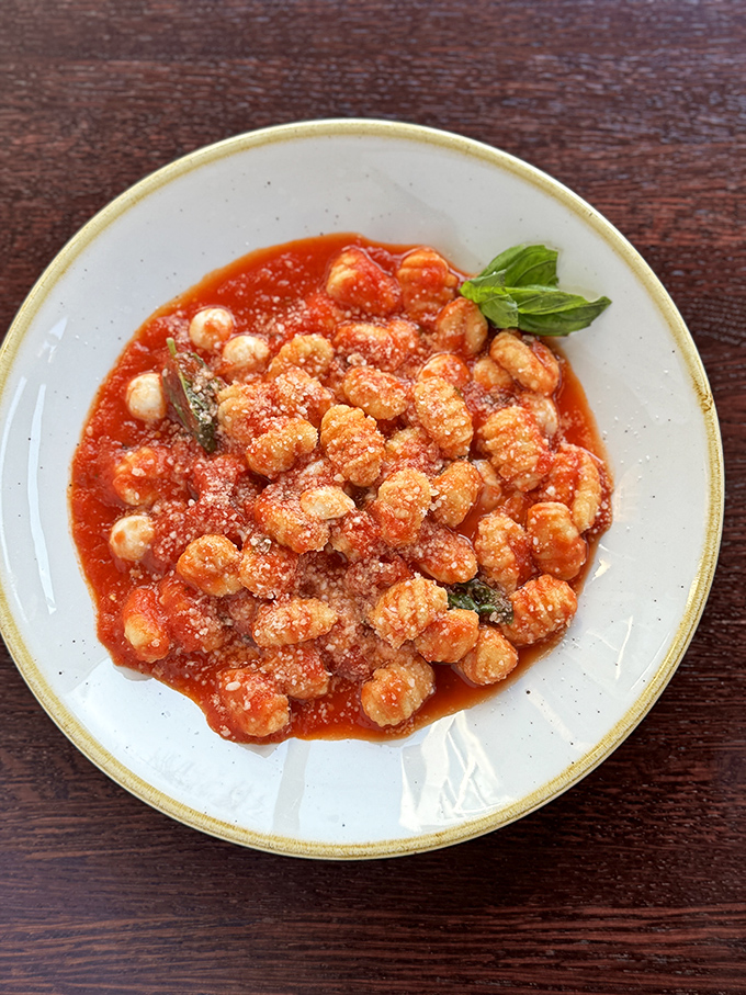 Gnocchi Sorrentina: Pillowy potato dumplings swimming in tomato sauce and melted cheese &ndash; comfort food that hugs your soul from the inside out.