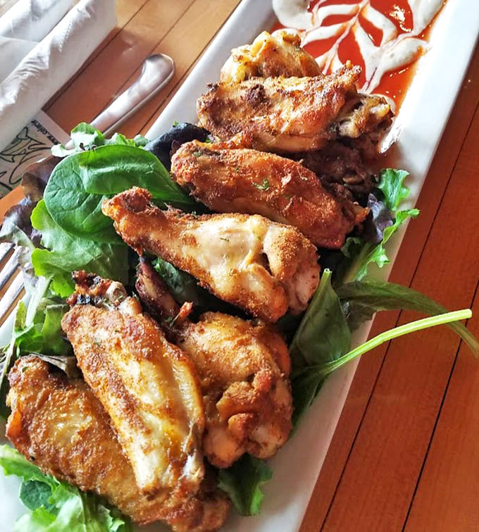 Golden-fried chicken wings served on fresh greens prove that bar food can be both indulgent and somewhat respectable.