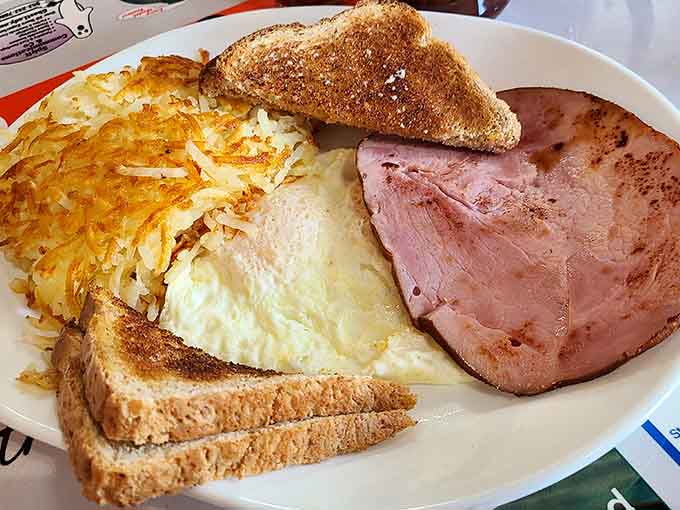 A classic breakfast plate showcasing perfectly cooked eggs, crispy hash browns, and toast that knows its place in the breakfast hierarchy.