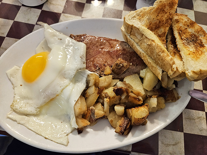 A classic breakfast plate featuring eggs, ham, and the star attraction &ndash; those incredible home fries.