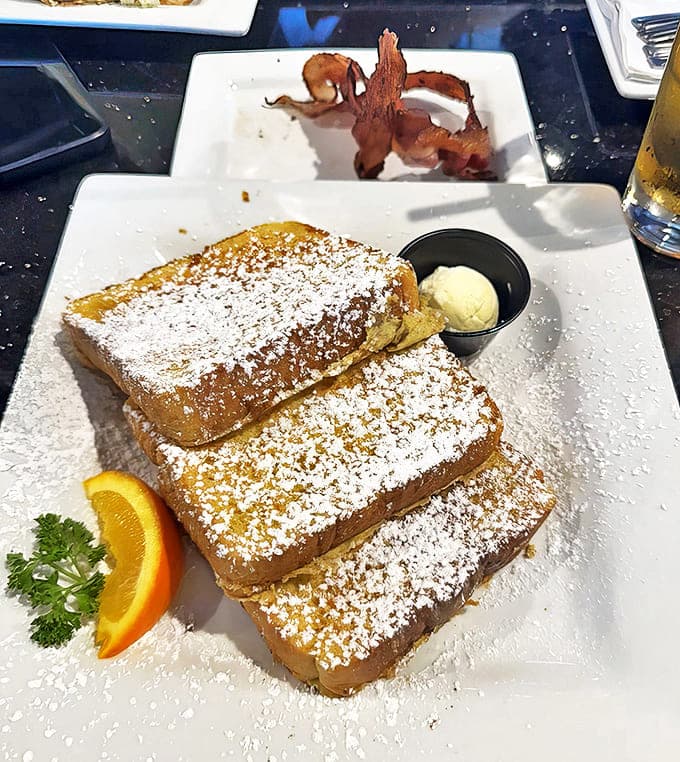 The House French Toast arrives dusted with powdered sugar like fresh snow, making you forget about calories faster than you can say "maple syrup."