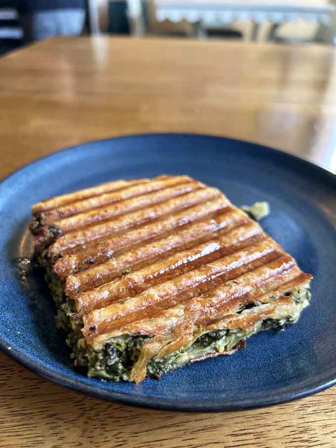 The spanakopita brings a Mediterranean twist to the menu, flaky and filled with spinach and cheese perfection.