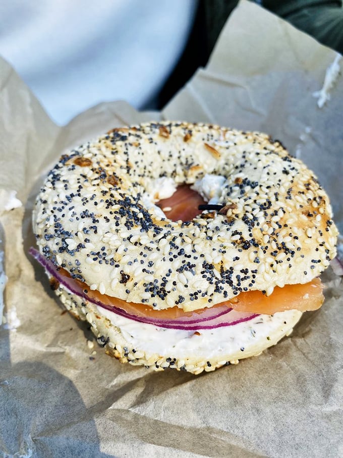 A poppy seed bagel cradles silky lox and red onion&mdash;proof that sometimes the simplest combinations deliver the most profound pleasure.