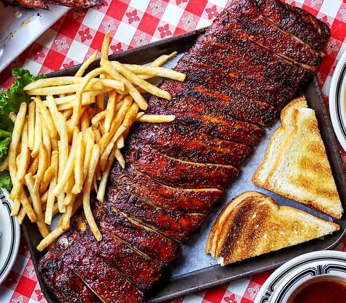 A full slab of ribs that would make Fred Flintstone jealous, complete with that mahogany bark that only comes from serious smoking skills.