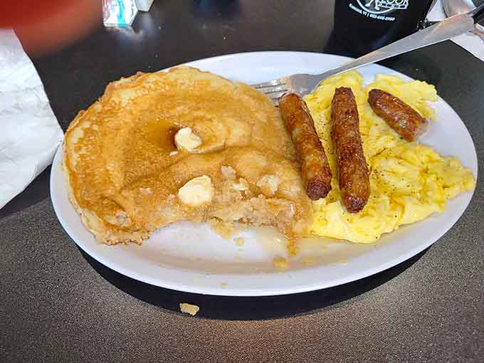The holy trinity of breakfast: pancakes, eggs, and sausage links working together in delicious harmony like a well-rehearsed band.